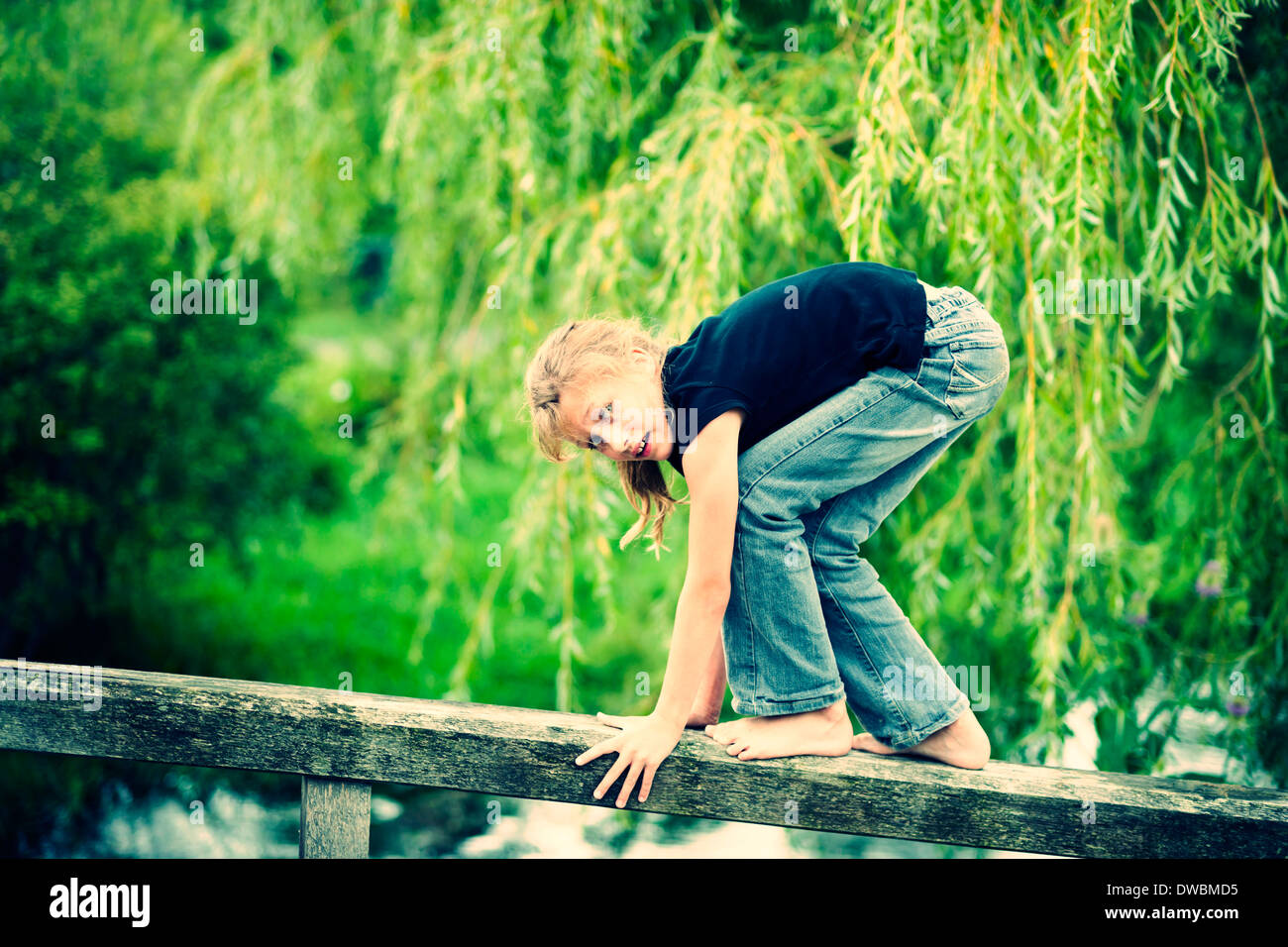 Girl balancing on railing of wooden boardwalk Stock Photo - Alamy