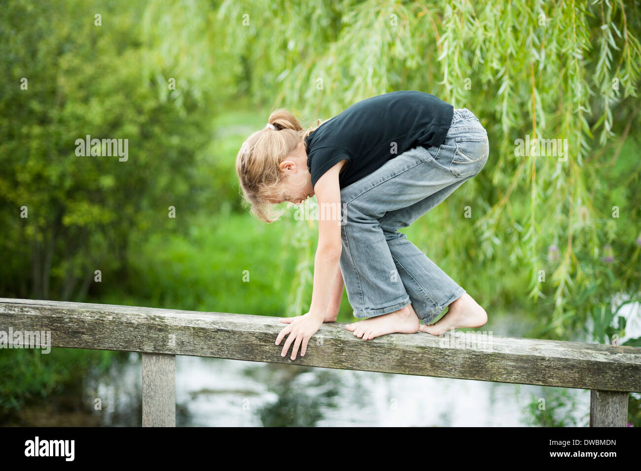 Girl balancing on railing of wooden boardwalk Stock Photo - Alamy