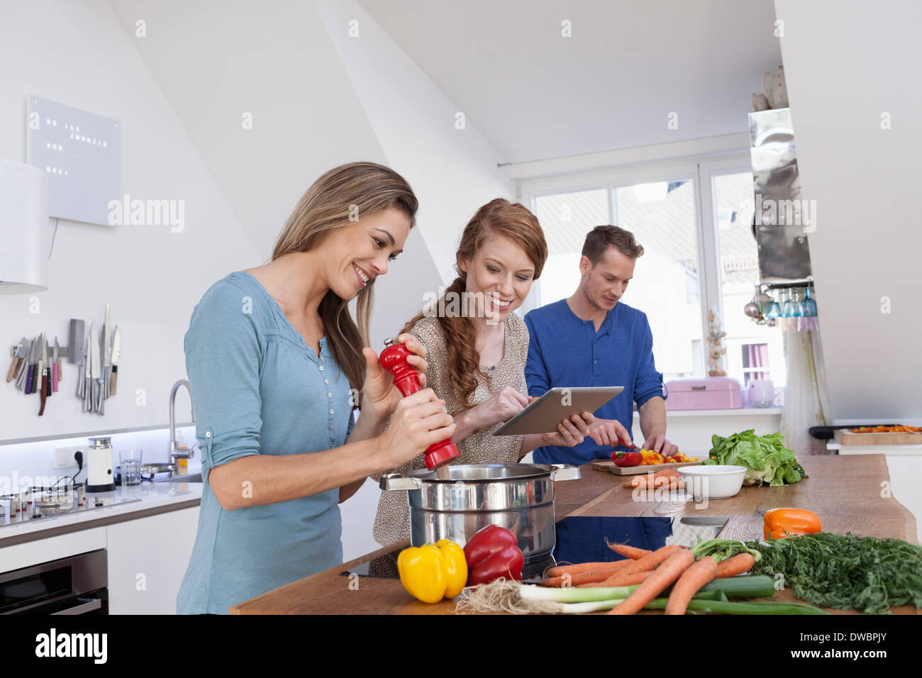 Three friends cooking together Stock Photo - Alamy