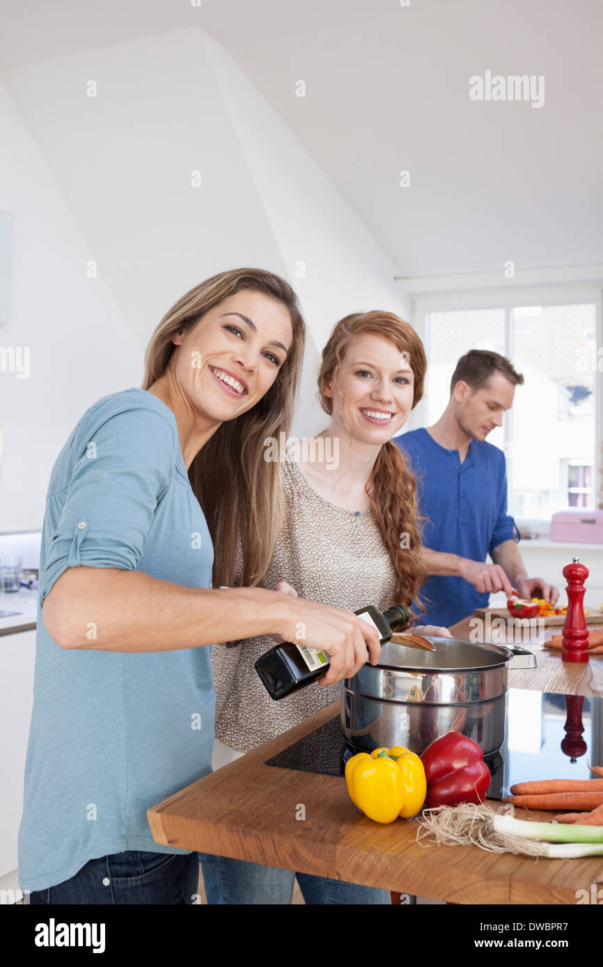 Three friends cooking together Stock Photo - Alamy