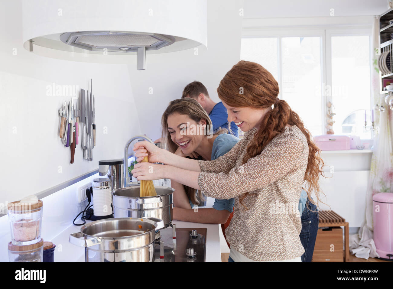 Three friends cooking together Stock Photo - Alamy