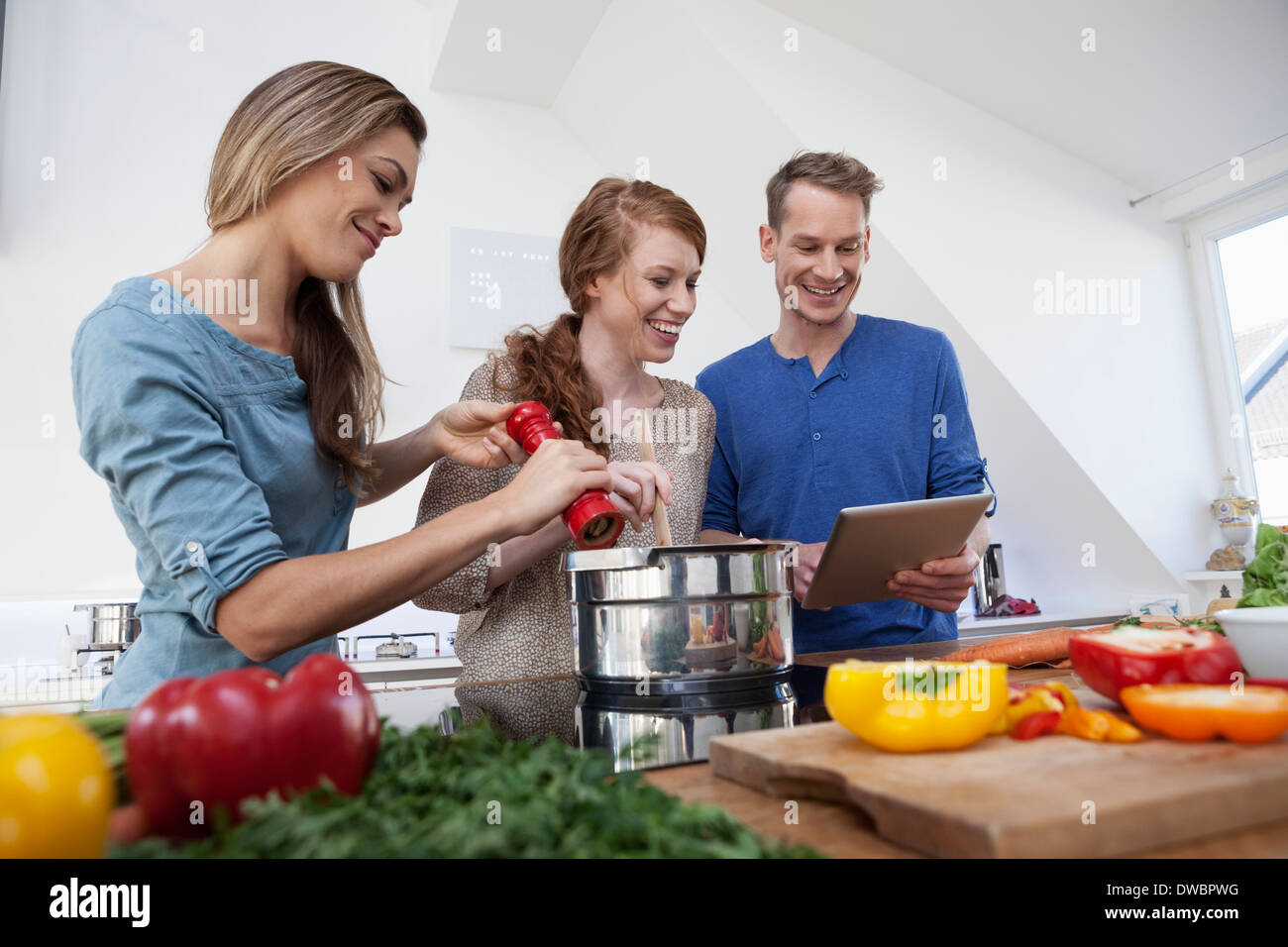 Three friends cooking together Stock Photo - Alamy