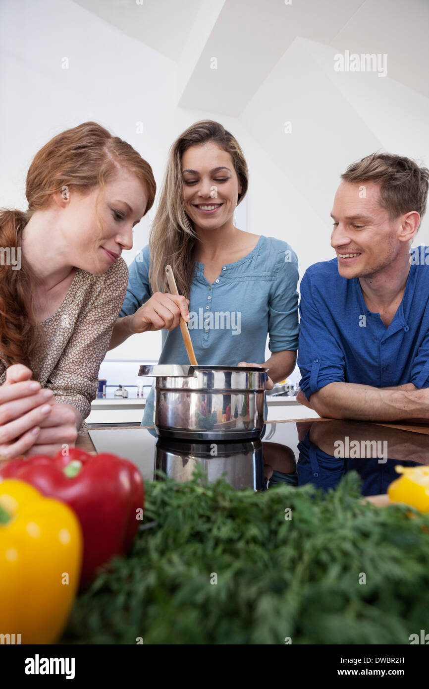 Three friends cooking together Stock Photo - Alamy