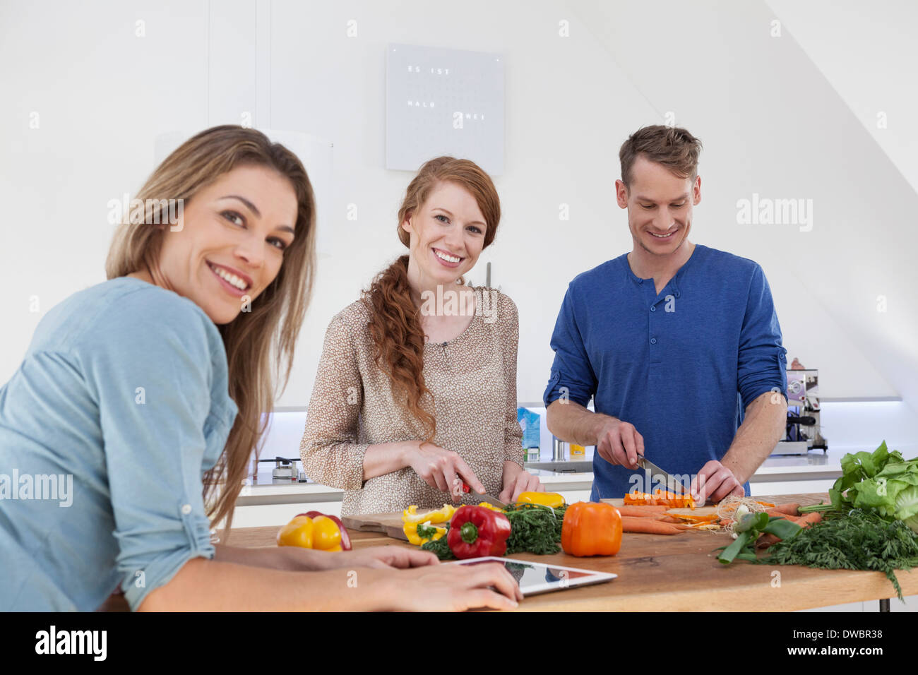 Three friends cooking together hi-res stock photography and images - Alamy