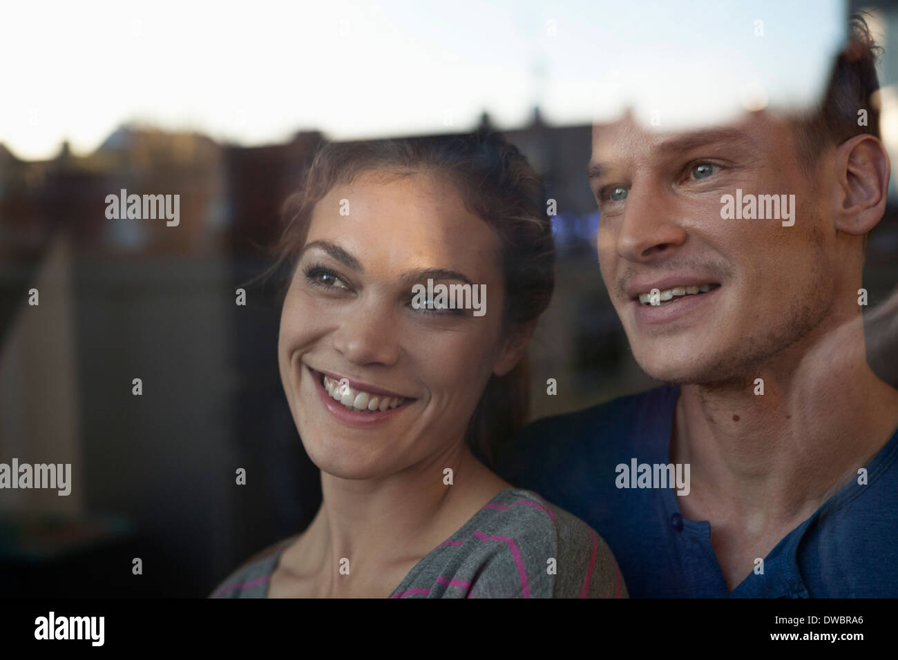Smiling couple behind window Stock Photo - Alamy