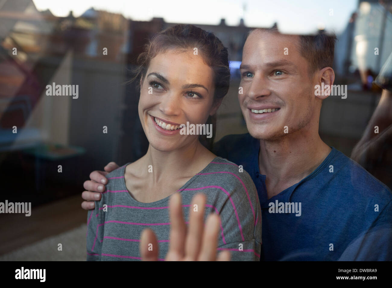 Smiling couple behind window Stock Photo - Alamy