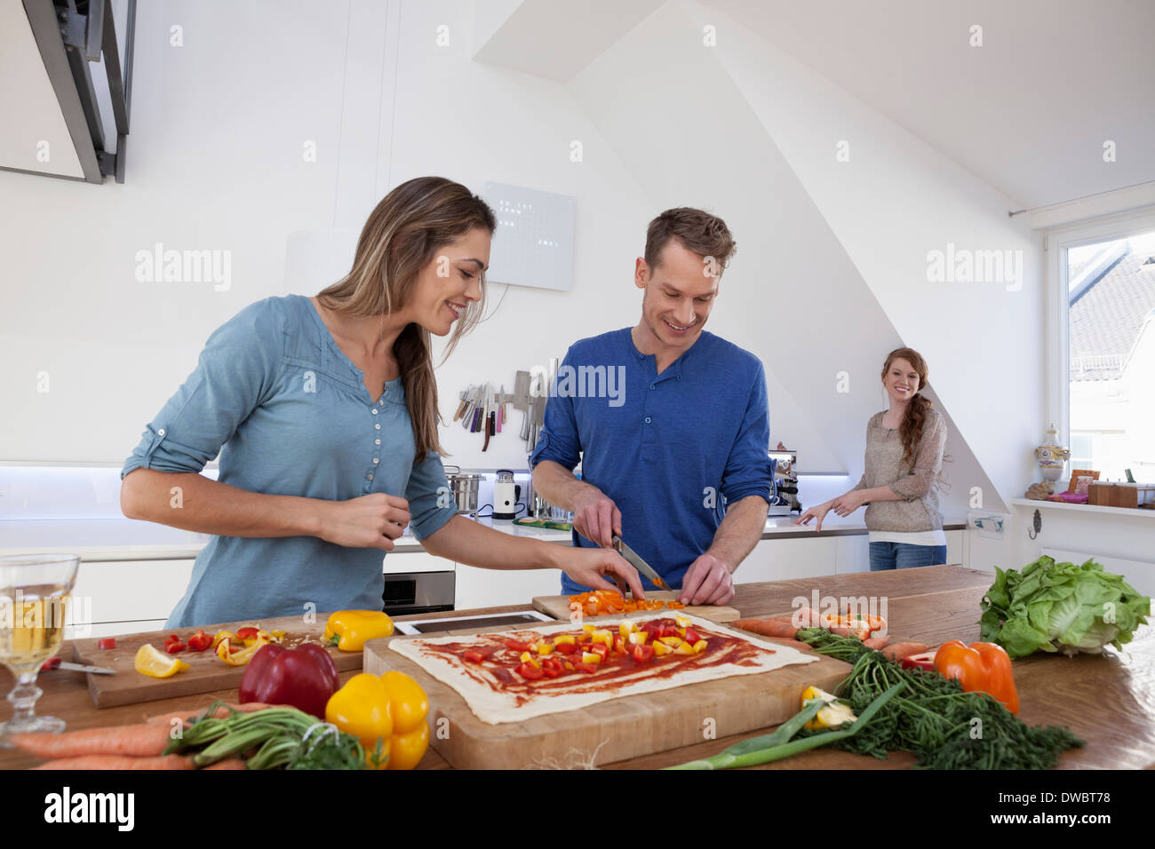 Three friends cooking together Stock Photo - Alamy