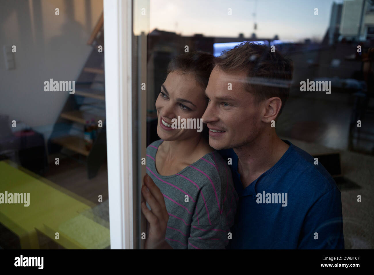 Smiling couple behind window Stock Photo - Alamy