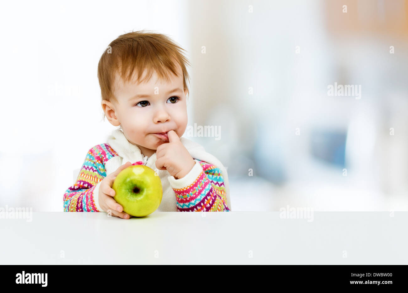 little child eating green apple Stock Photo - Alamy