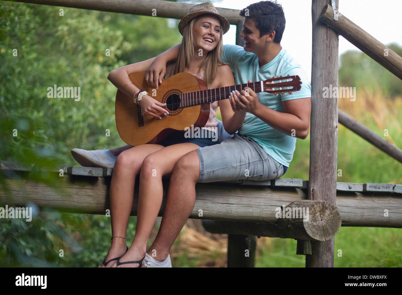 Teenage couple playing guitar and singing Stock Photo - Alamy