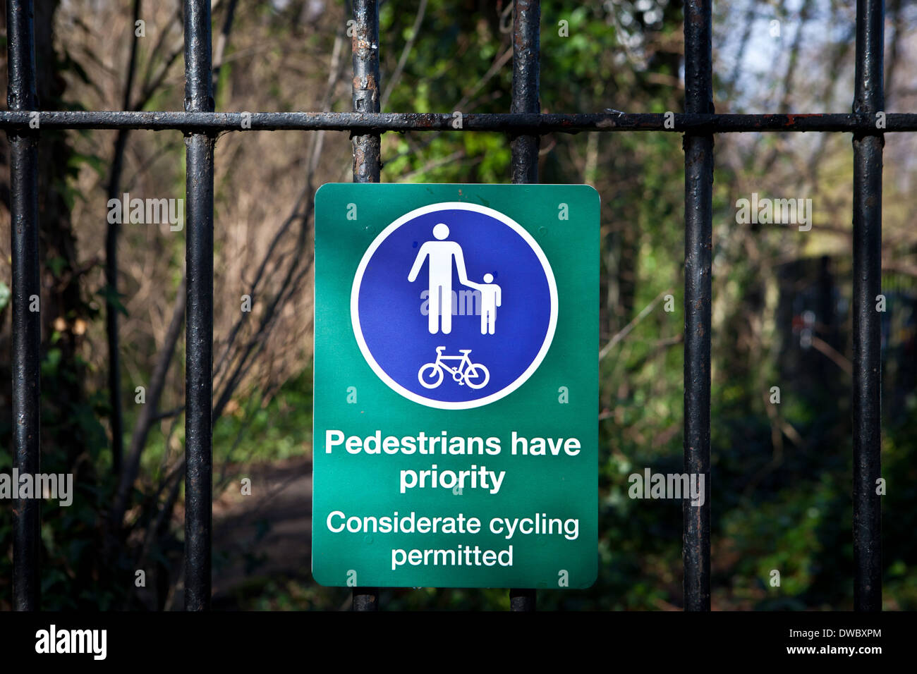 A sign on railings giving pedestrians priority in a wooden walk way ...