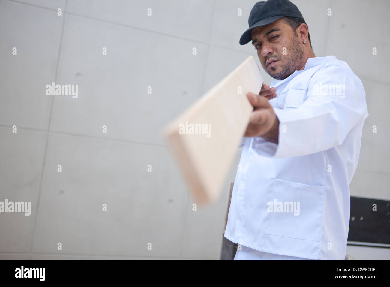Builder checking wood plank Stock Photo - Alamy