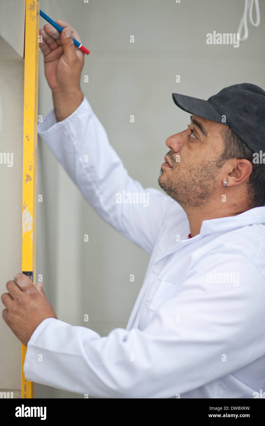 Builder marking wall with pencil Stock Photo - Alamy