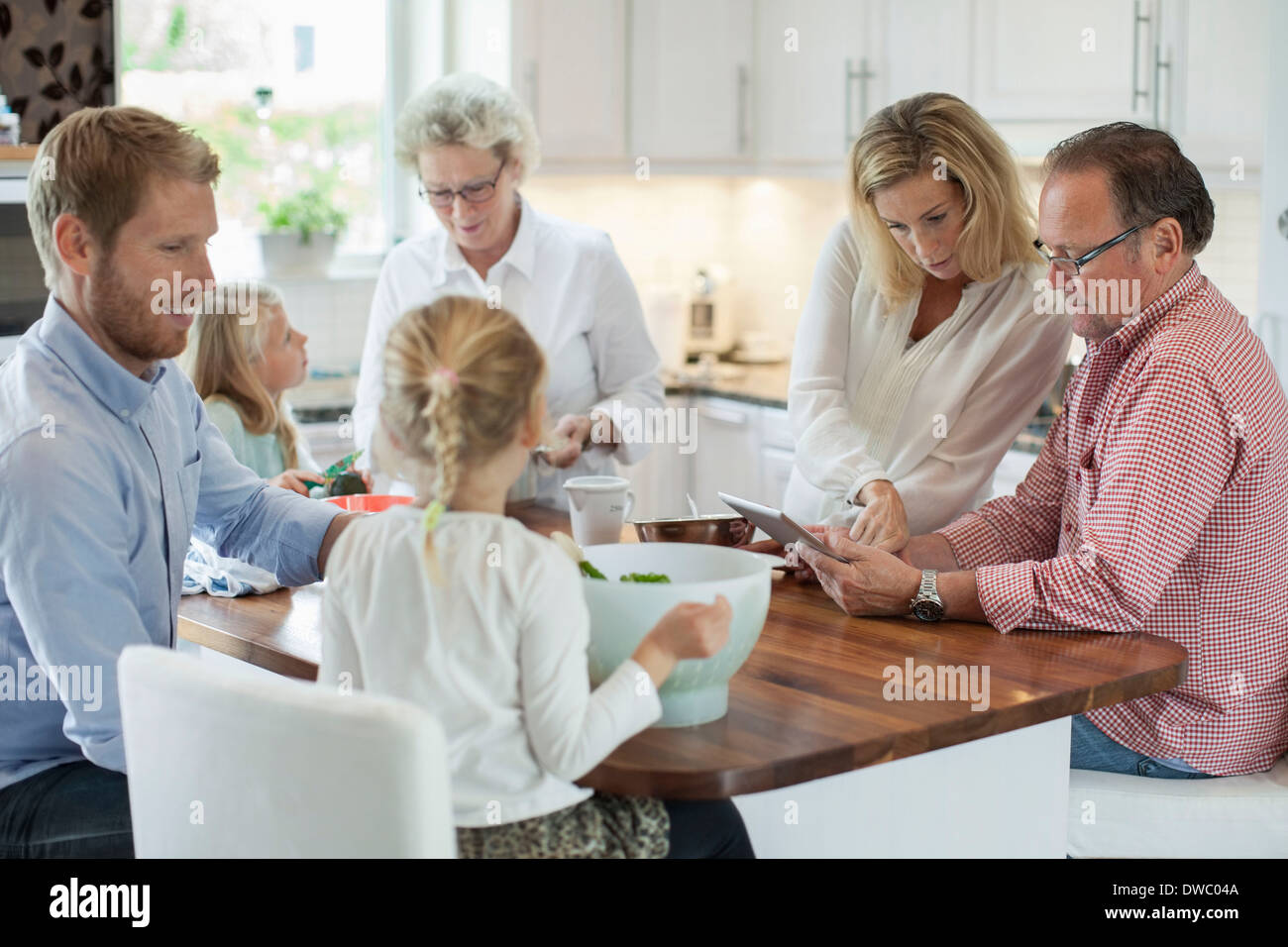 Three generation family preparing food in kitchen Stock Photo - Alamy