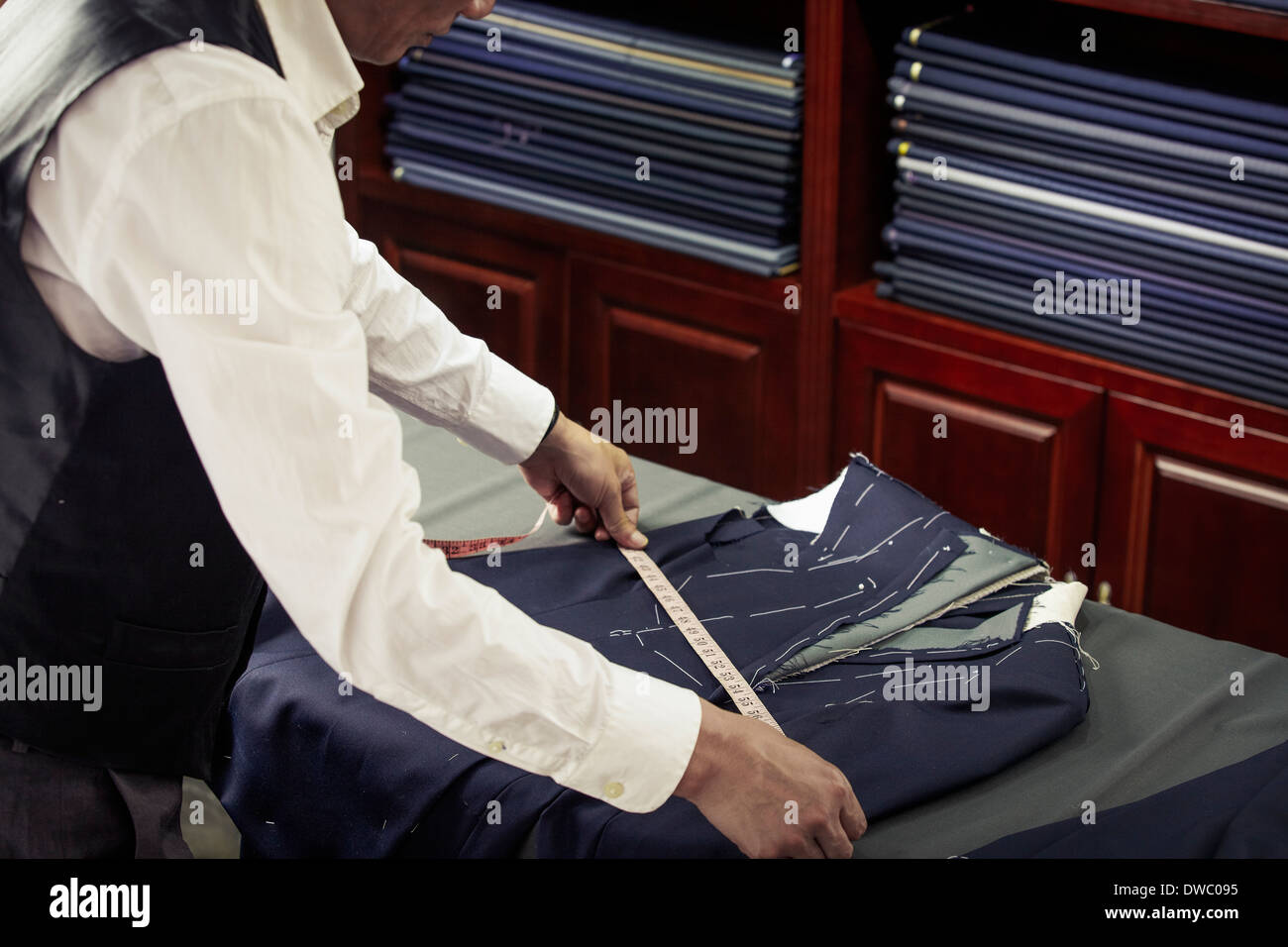 Tailor measuring garment in tailors shop Stock Photo - Alamy