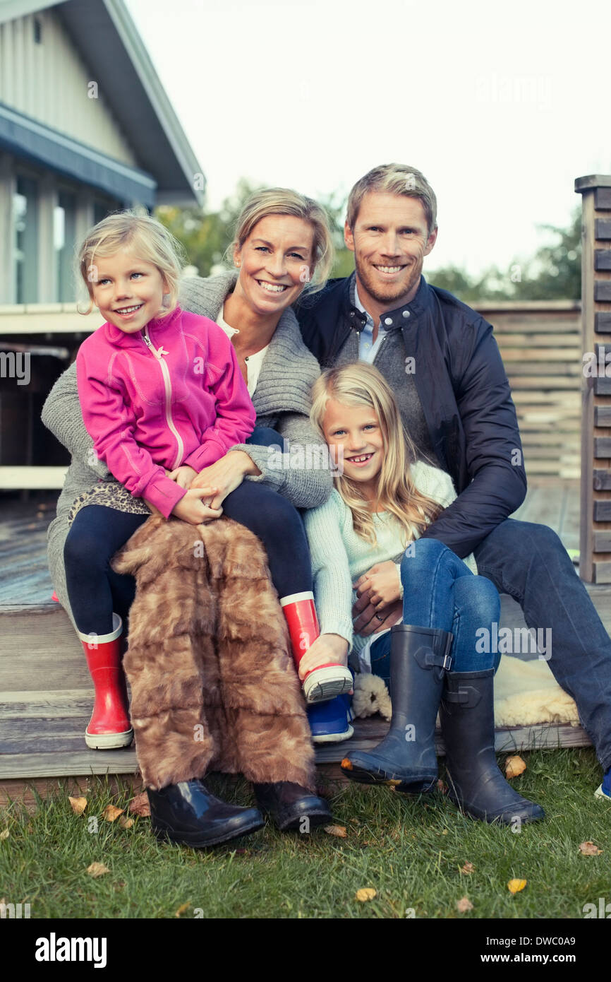 Portrait of happy two generation family sitting together in yard Stock ...