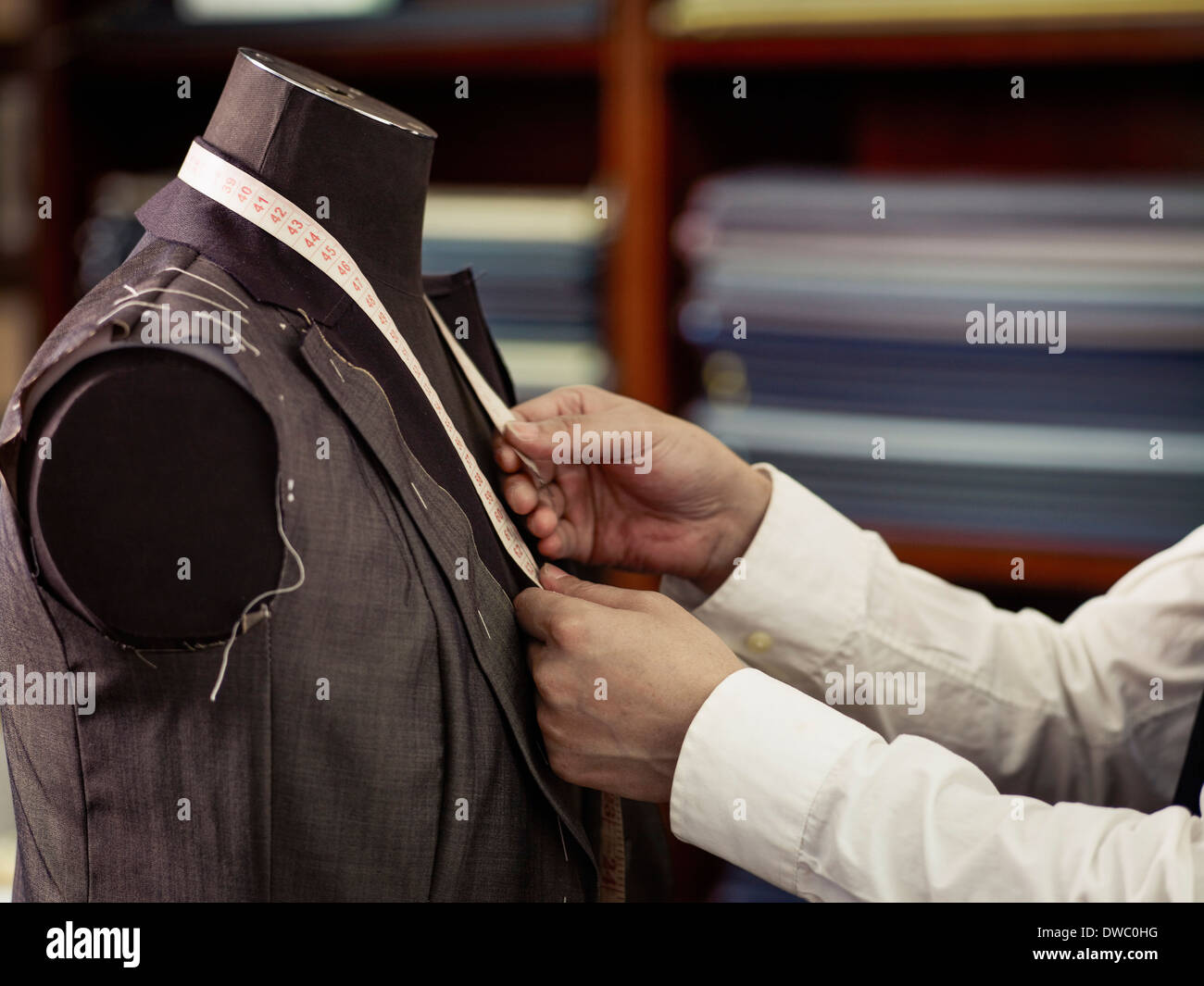 Tailor measuring garment in traditional tailors shop Stock Photo - Alamy