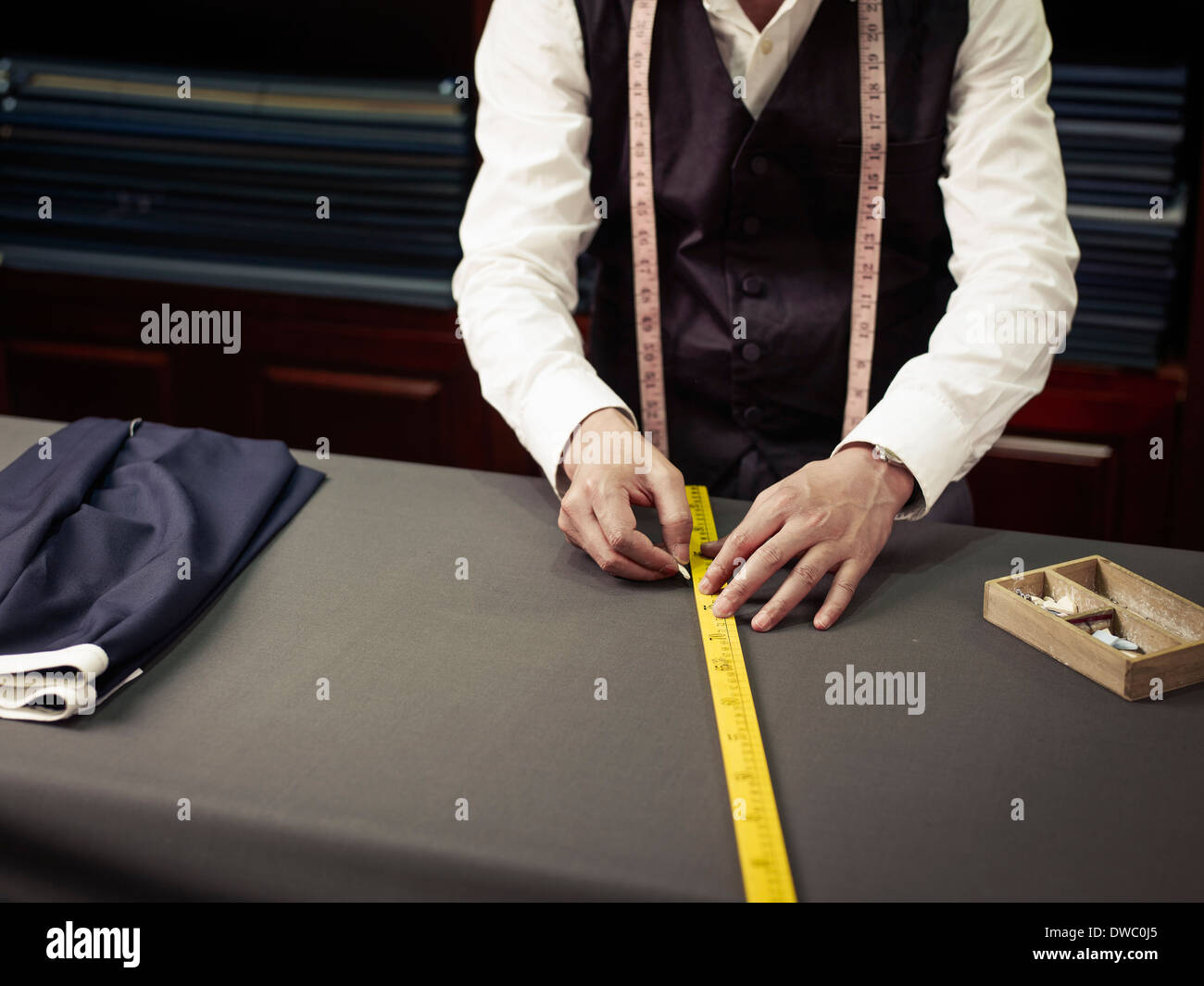 Tailor chalking measurements in traditional tailors shop Stock Photo ...