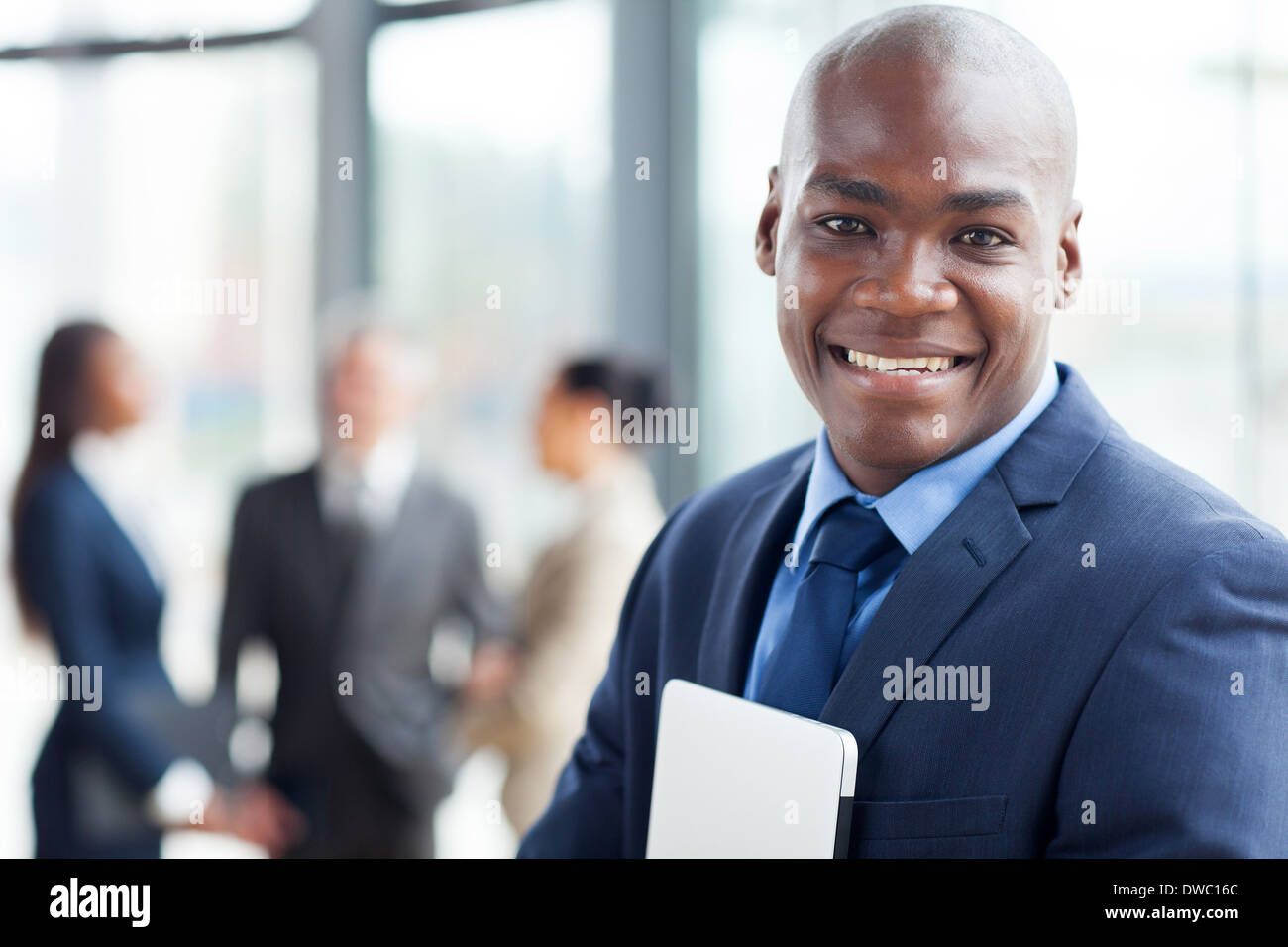 young African corporate worker in modern office with colleagues on ...