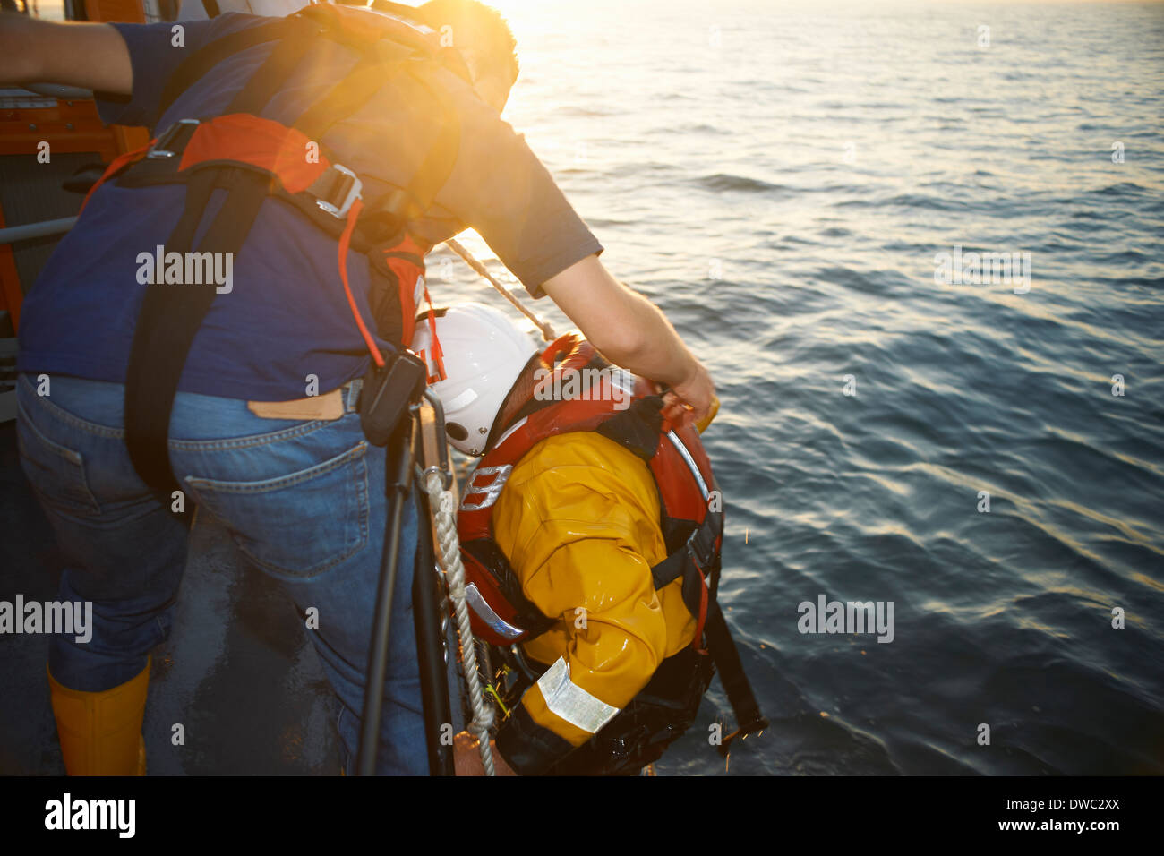 Lifeboat crew training and pulling up team member from sea Stock Photo ...