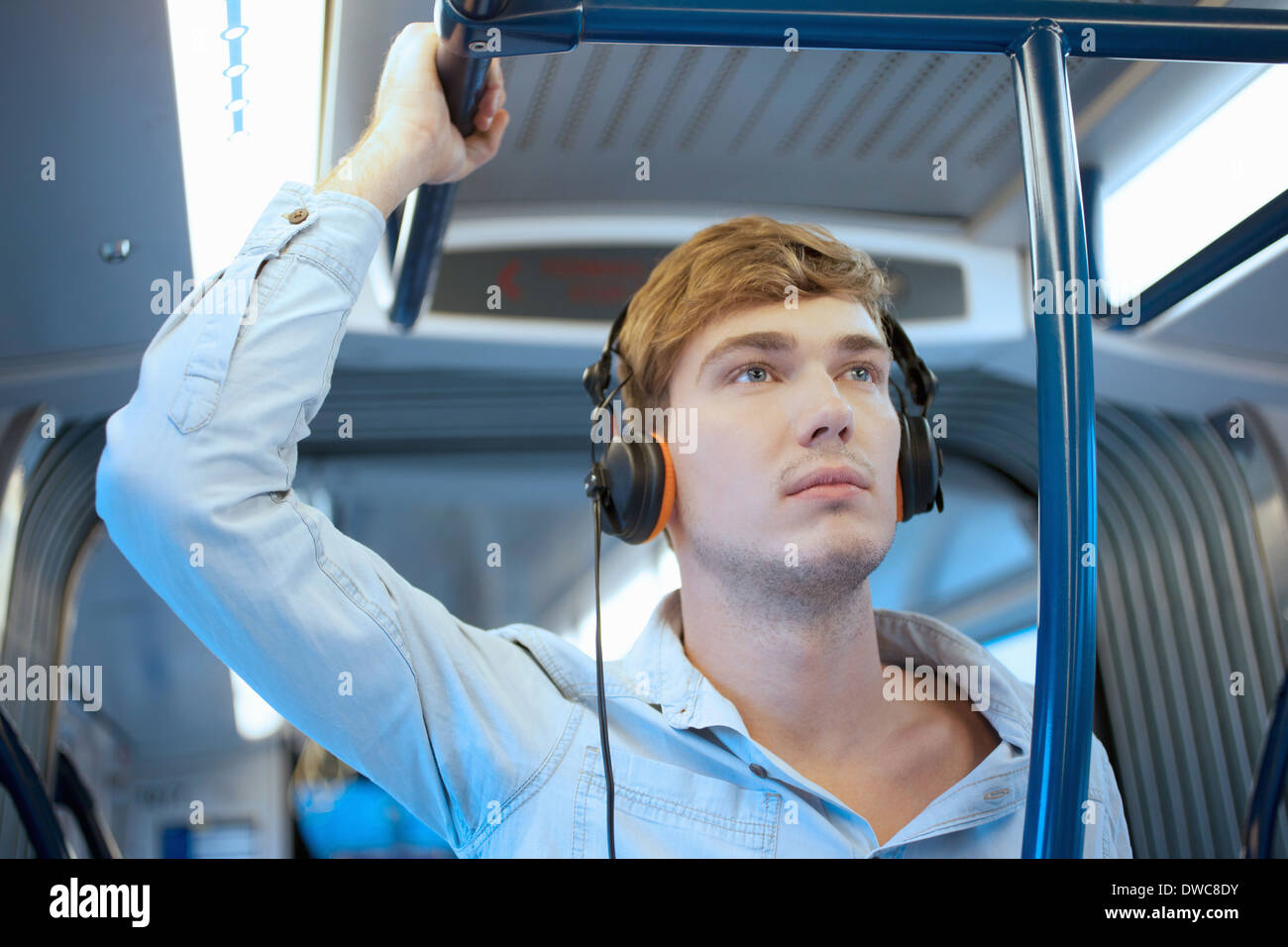 Young man in train carriage listening to headphones Stock Photo - Alamy
