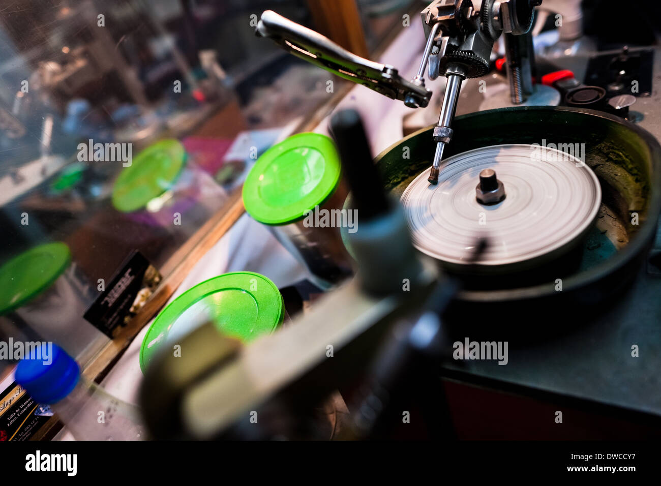 An emerald gemstone seen being polished on a machine a in a cutting and ...