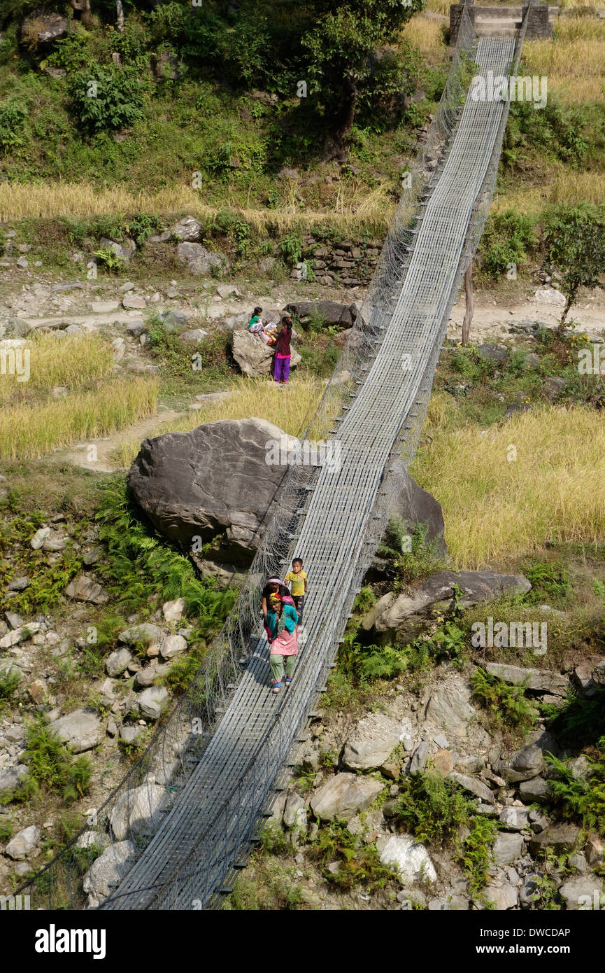 Nepalese family crossing suspension bridge in the Manaslu region of ...