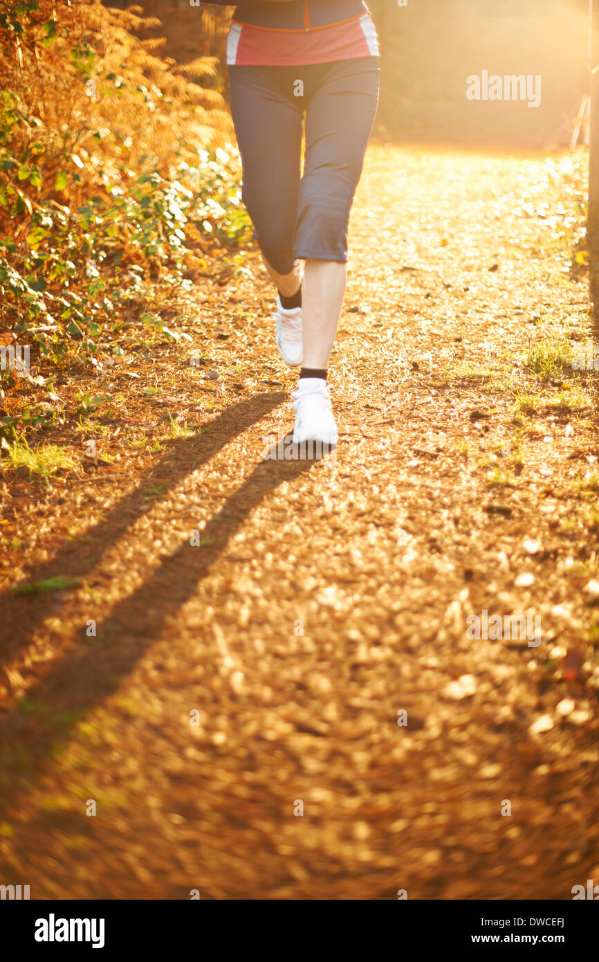 Mature woman jogging on path in sunlight, low section Stock Photo - Alamy