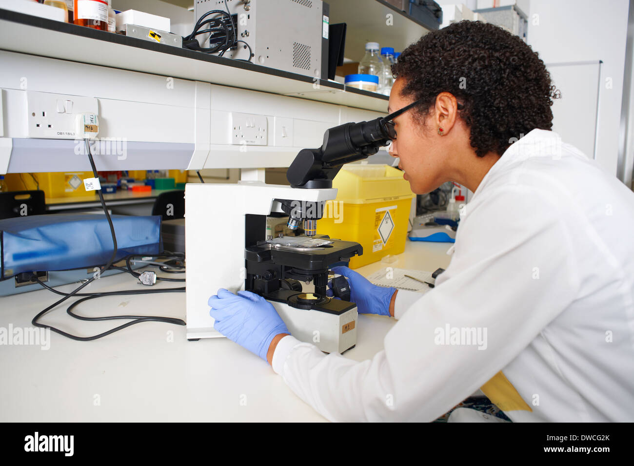 Female scientist looking through microscope Stock Photo - Alamy