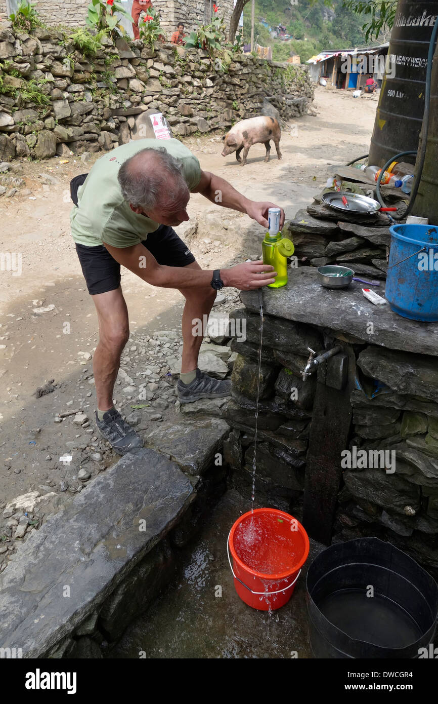 Trekker sterilizing water using a Steripen on a trek in the Himalayan ...