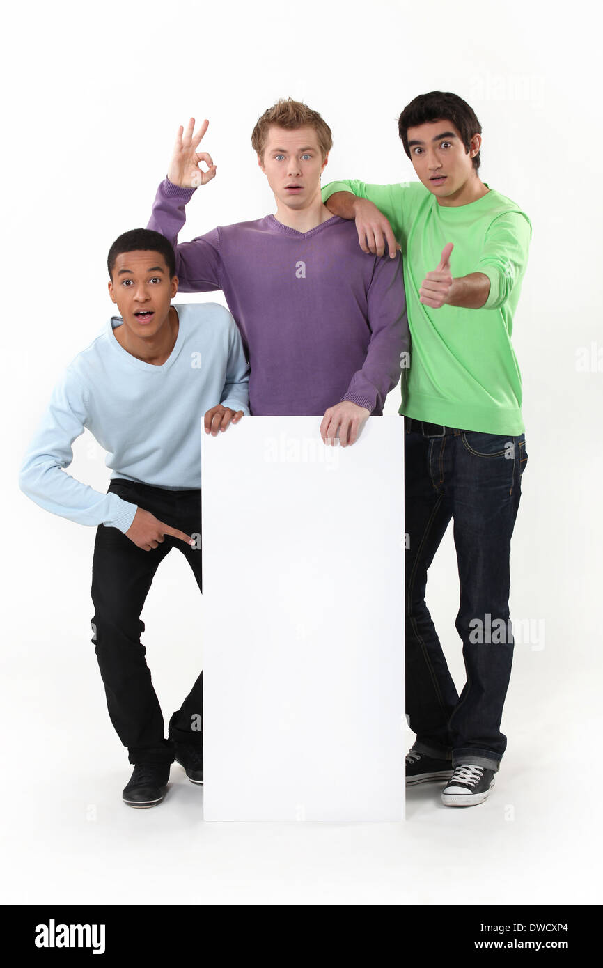 Friends gathered around poster Stock Photo - Alamy