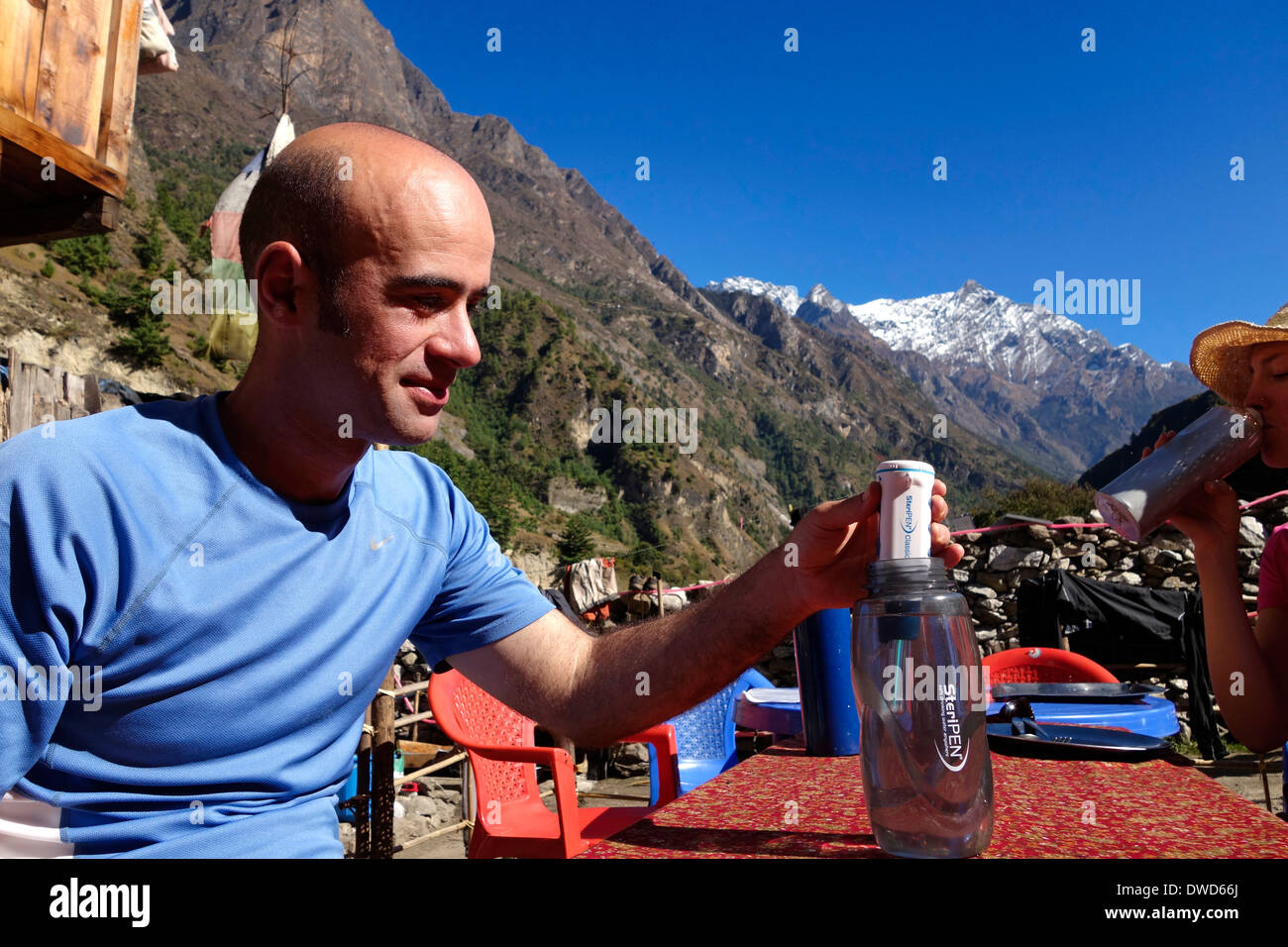 Trekker sterilizing water using a Steripen on a trek in the Himalayan ...