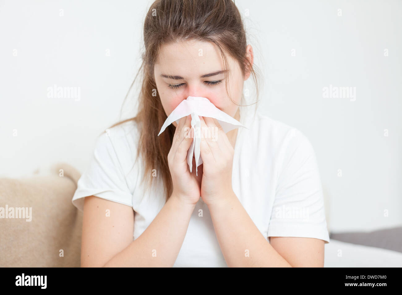 Portrait of brunette woman sneezing Stock Photo - Alamy