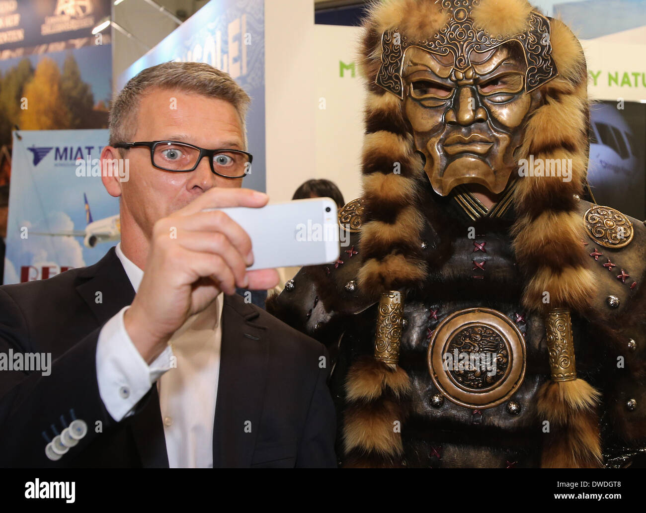Berlin, Germany. 5th Mar, 2014. A fair-goer takes photos with his ...