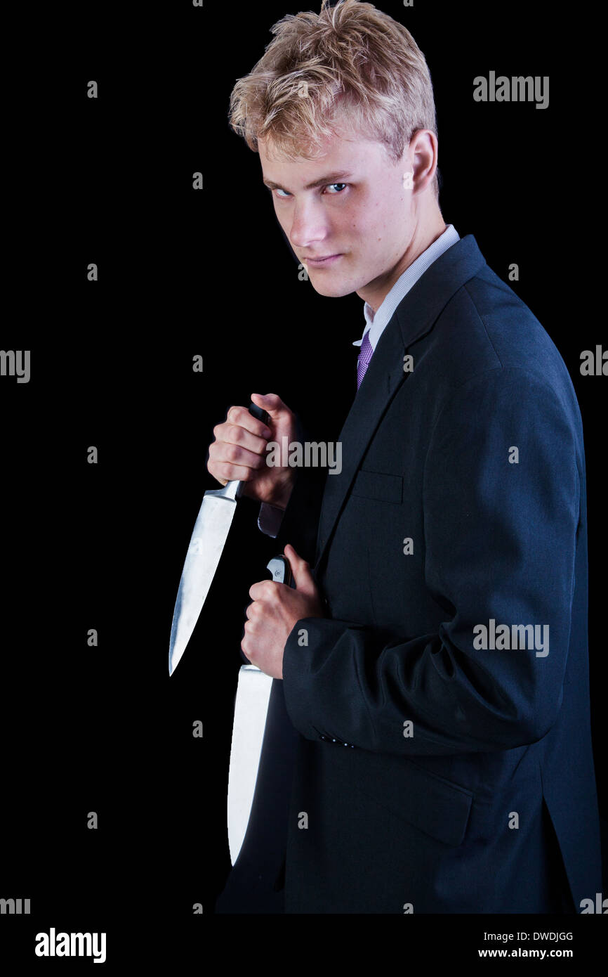 Young corporate male wielding knives considering corporate or staff ...