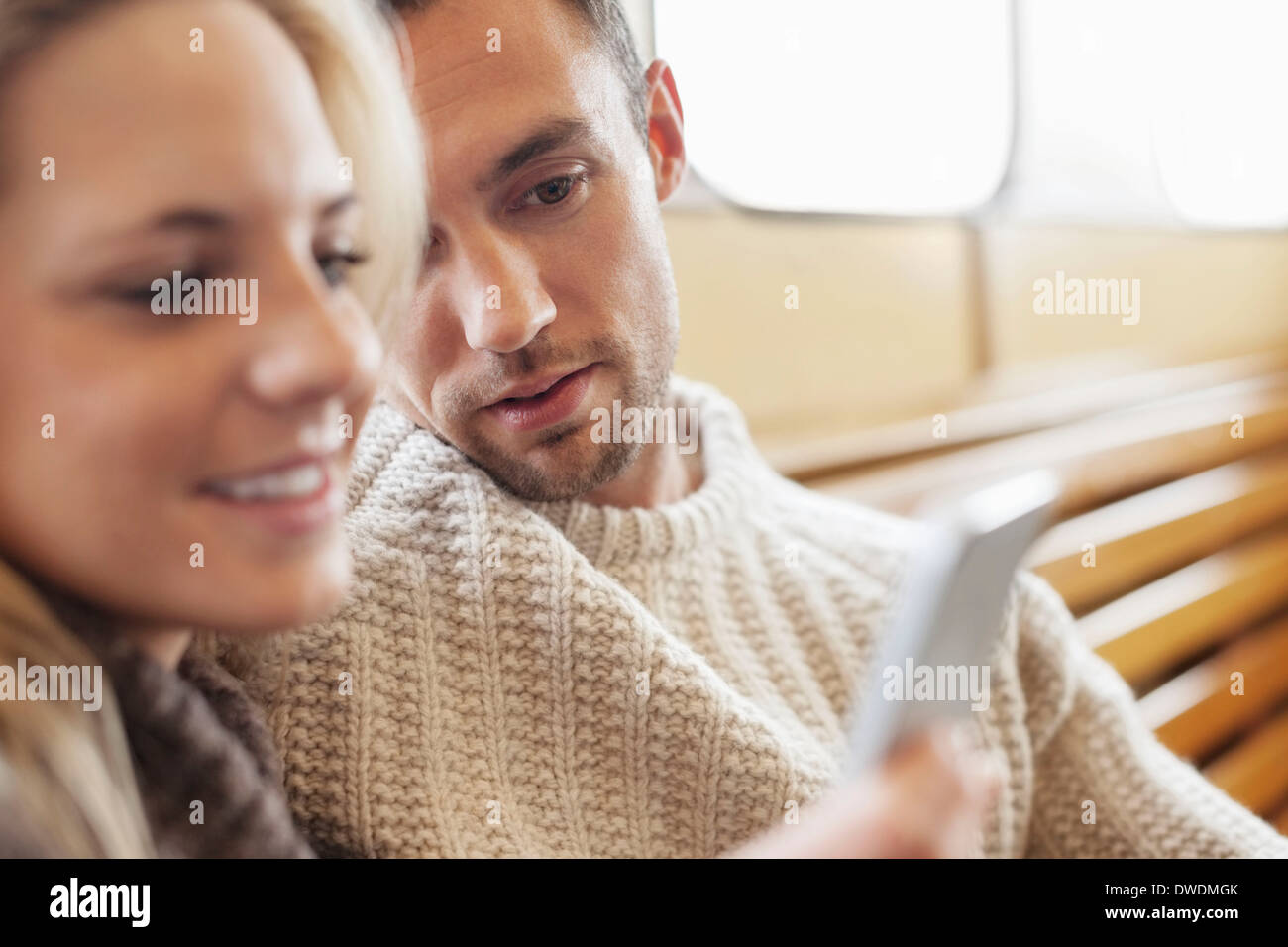 Couple using mobile phone together on ferry Stock Photo - Alamy