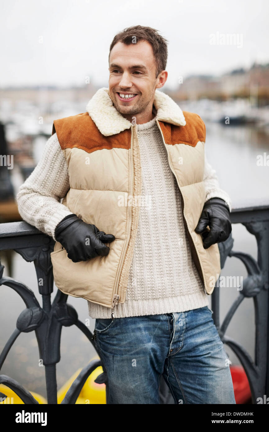 Happy man leaning on railing outdoors Stock Photo - Alamy