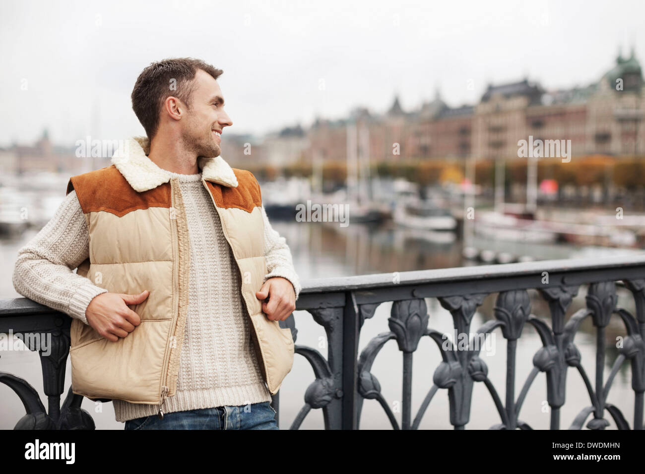 Young man leaning on railing outdoors Stock Photo - Alamy