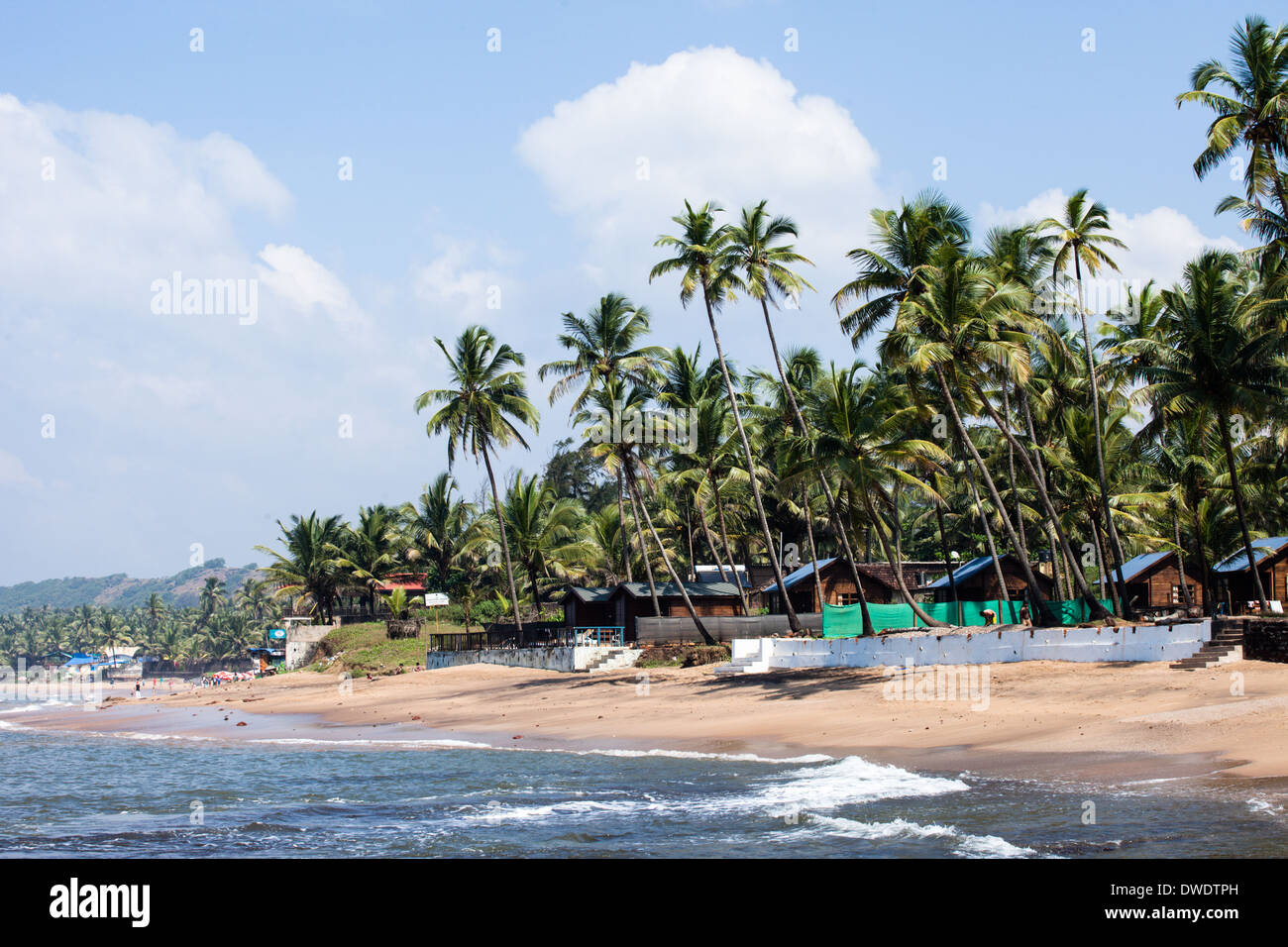 Exiting Anjuna beach panorama on low tide with white wet sand and green ...
