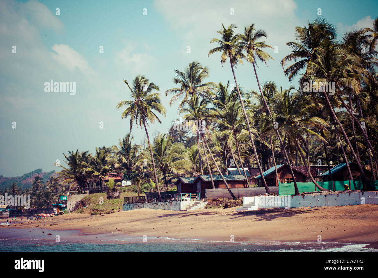 Exiting Anjuna beach panorama on low tide with white wet sand and green ...