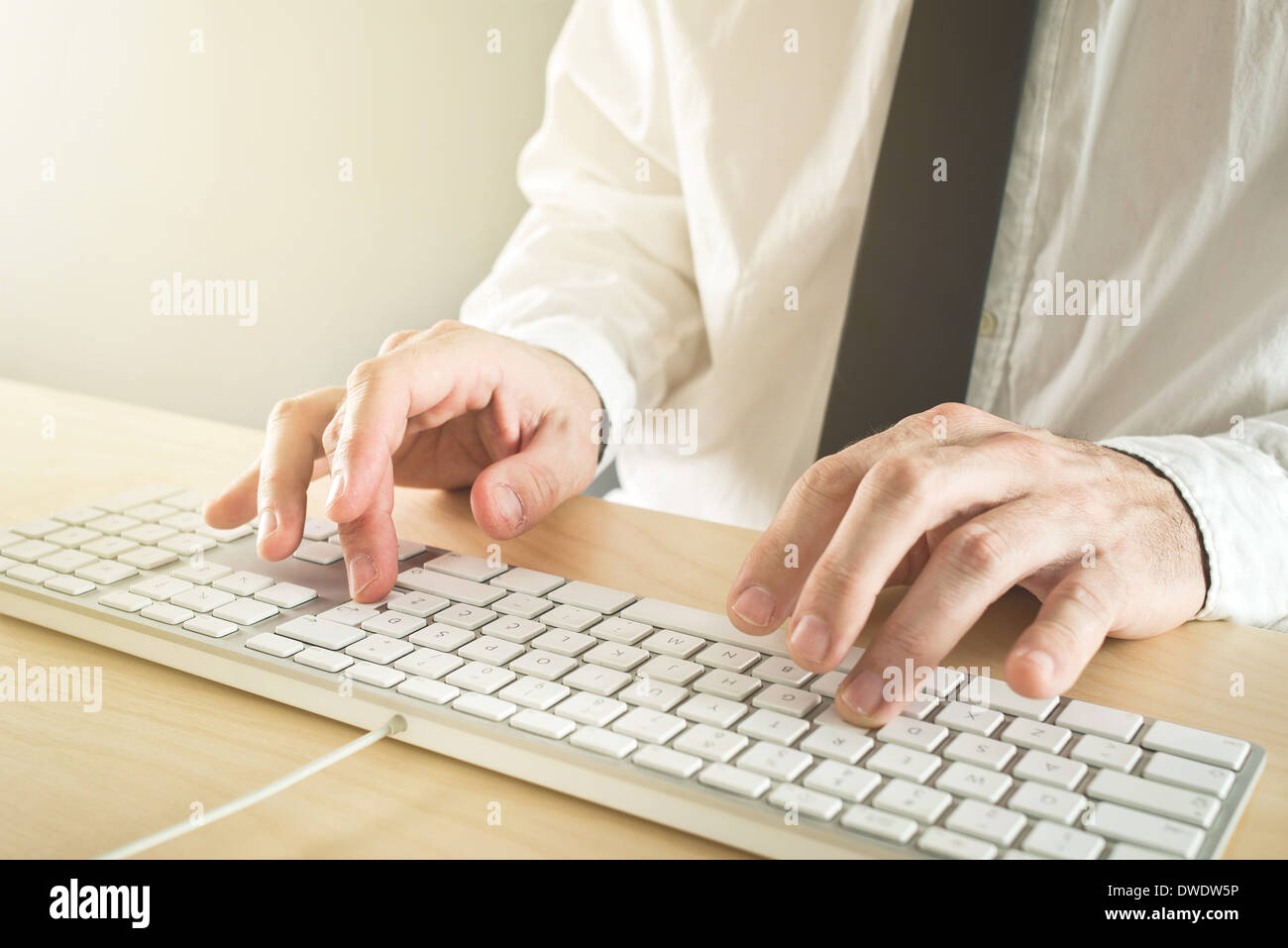 Businessman typing on his computer at office desk Stock Photo - Alamy
