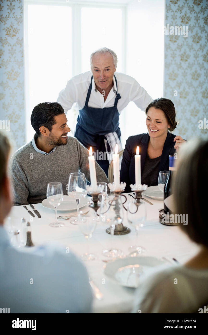 Senior chef talking to business people at dining table in restaurant ...