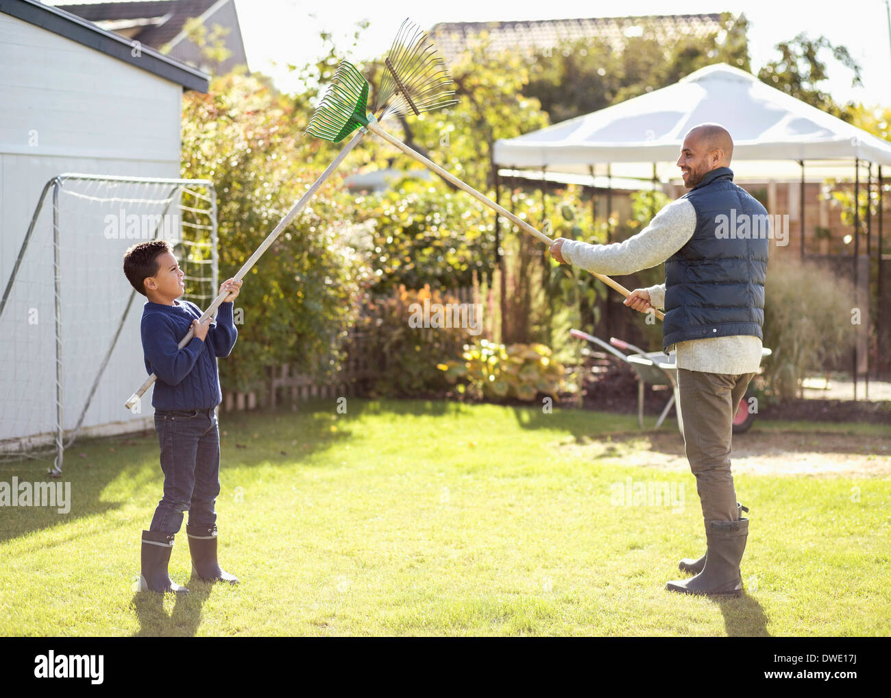 Father and son fighting with rakes at garden Stock Photo - Alamy