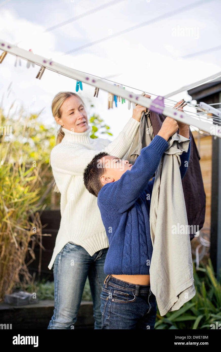 Mother and son drying laundry at yard Stock Photo - Alamy