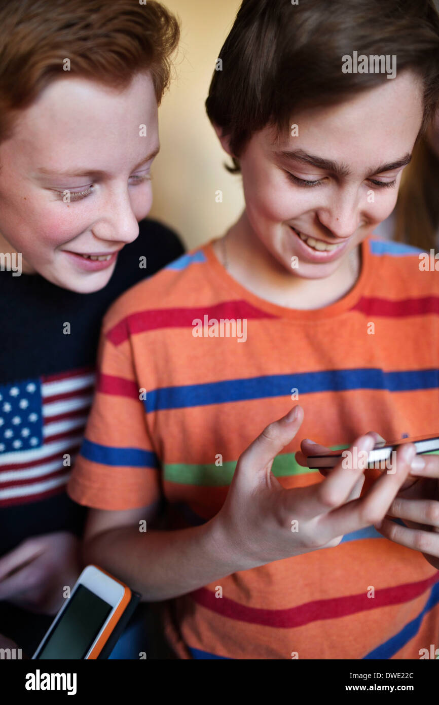 Happy boys using mobile phone in high school Stock Photo - Alamy
