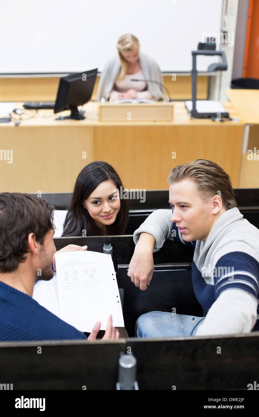 University students discussing while studying in lecture theatre Stock ...