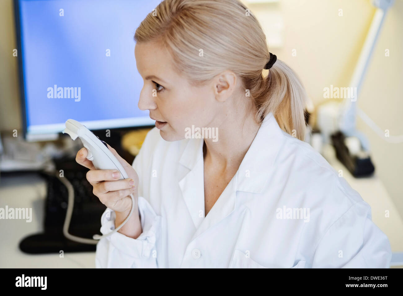 Female doctor using dictation device in office Stock Photo - Alamy