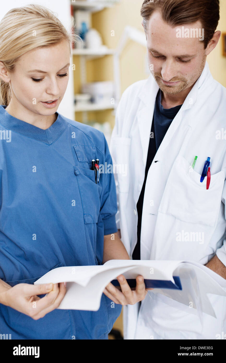 Doctor and nurse reading file in hospital Stock Photo - Alamy