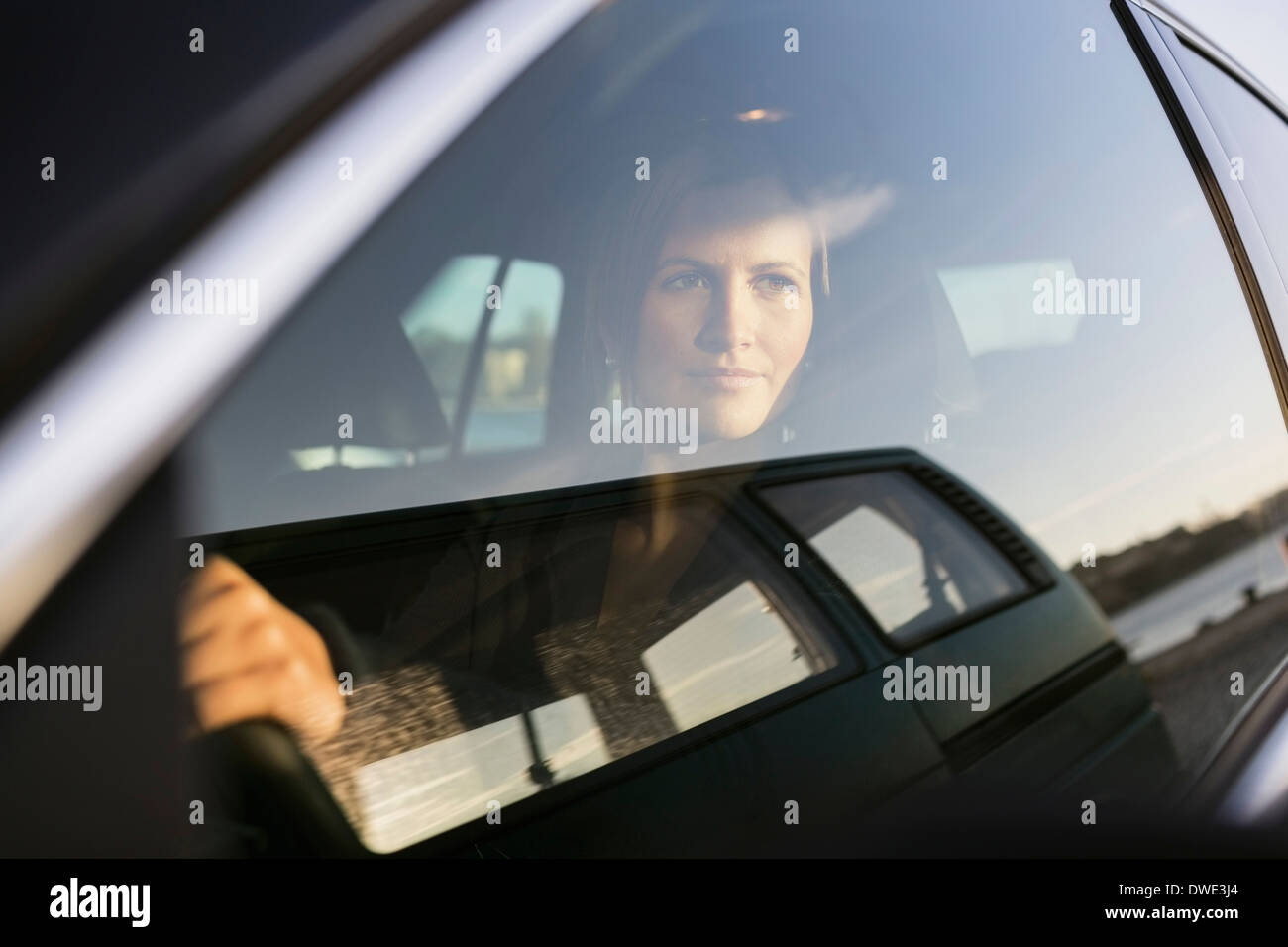 Businesswoman looking through window while driving car Stock Photo - Alamy
