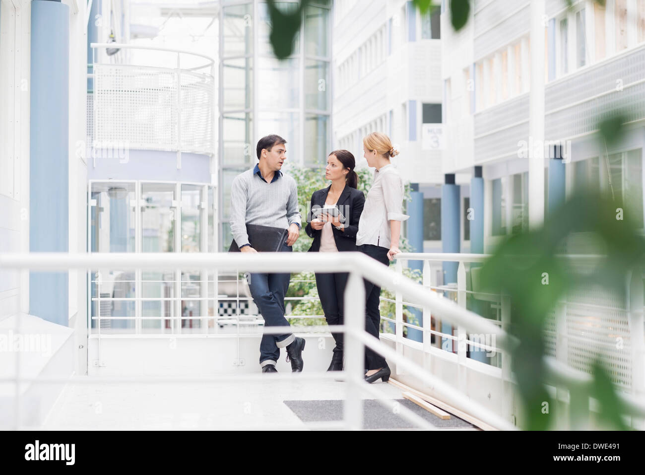 Business people communicating at office balcony Stock Photo - Alamy